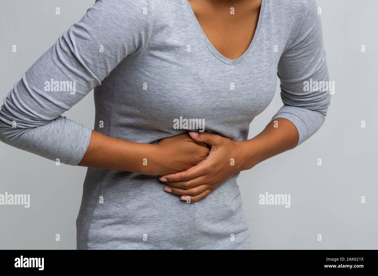 Cropped of black woman suffering from gastritis, touching her tummy ...