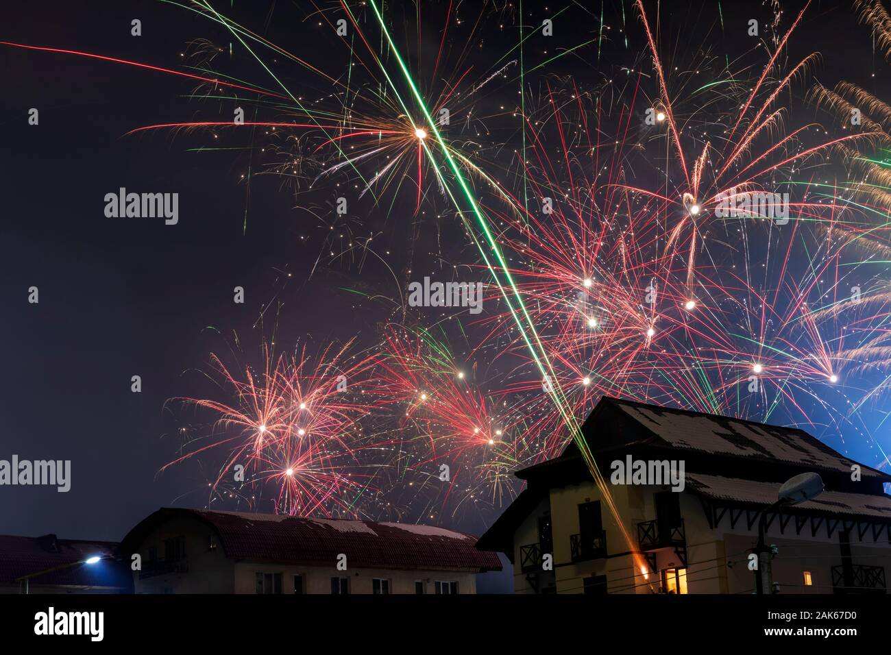 Fireworks over the snowy roofs on New Year's Eve Stock Photo - Alamy