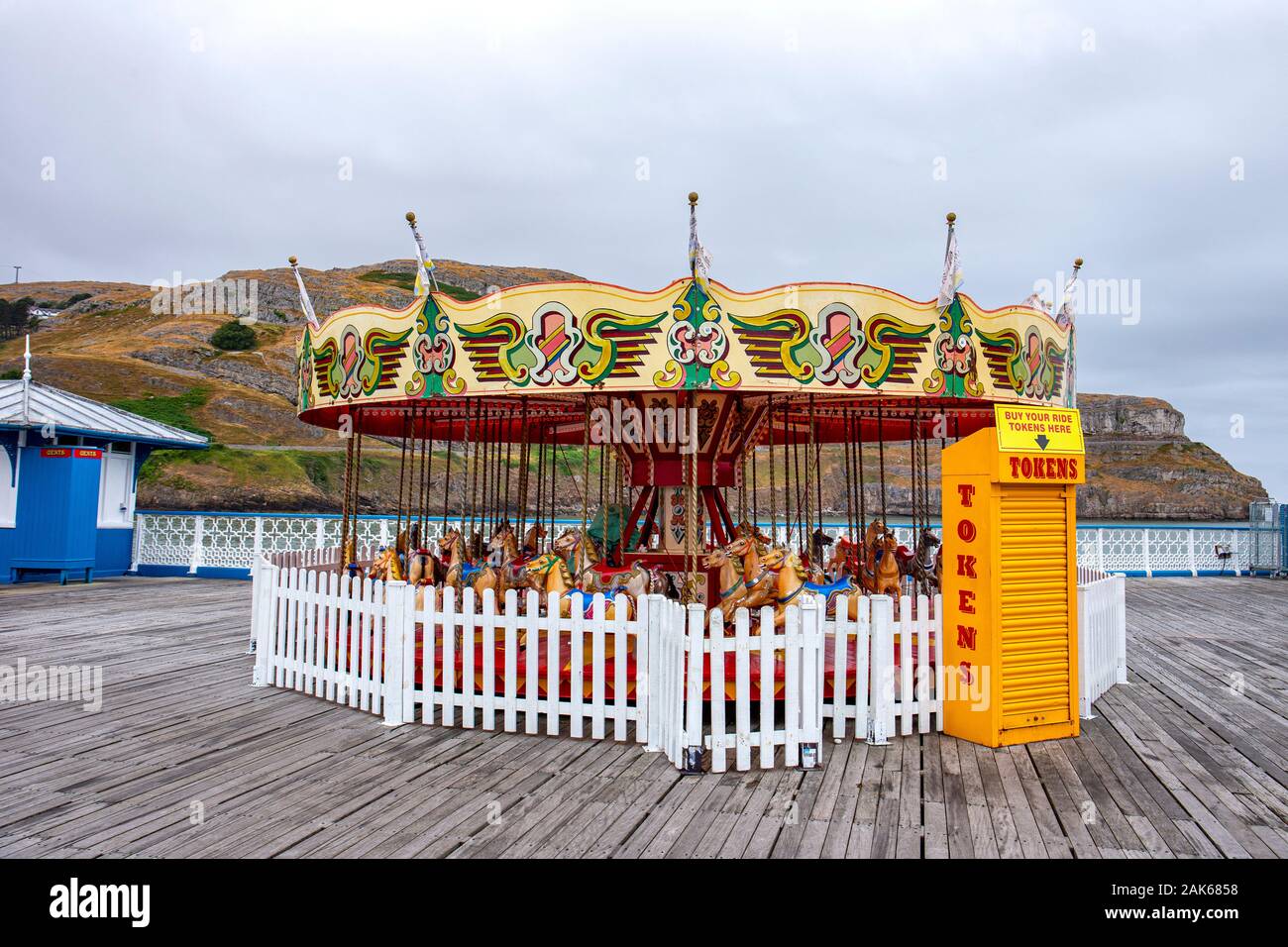 Traditional carousel fair ground ride on the pier in Llandudno Wales UK ...