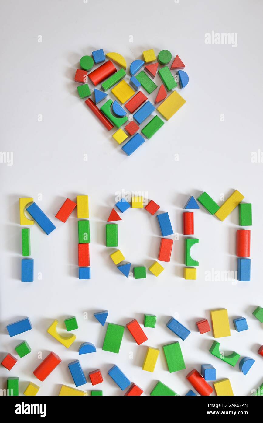 colorful wooden toy blocks lettering the word MOM and a heart on white ...