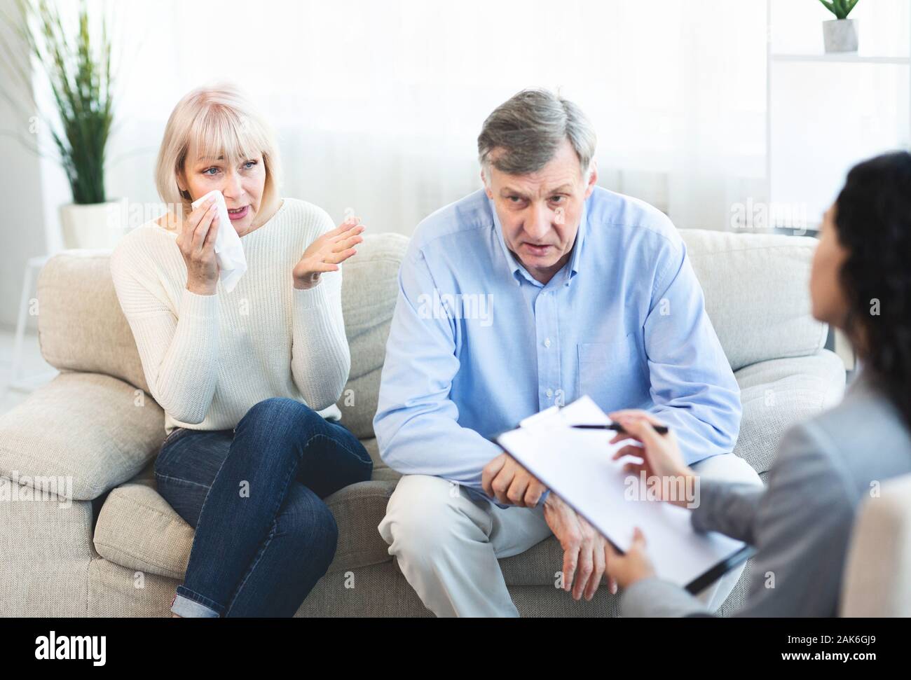 Marriage Counseling. Senior couple sitting on couch and talking to ...