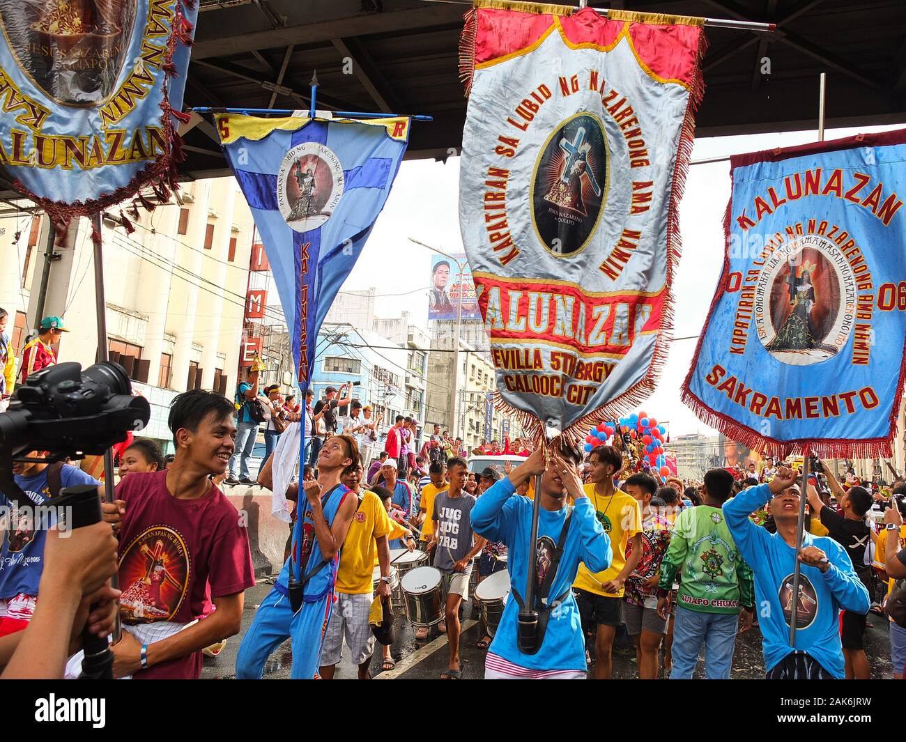 Black Nazarene devotees hold flags and banners during the procession ...