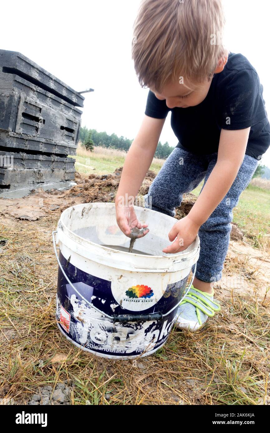 Boy age three getting the feel of concrete used for building an outdoor ...