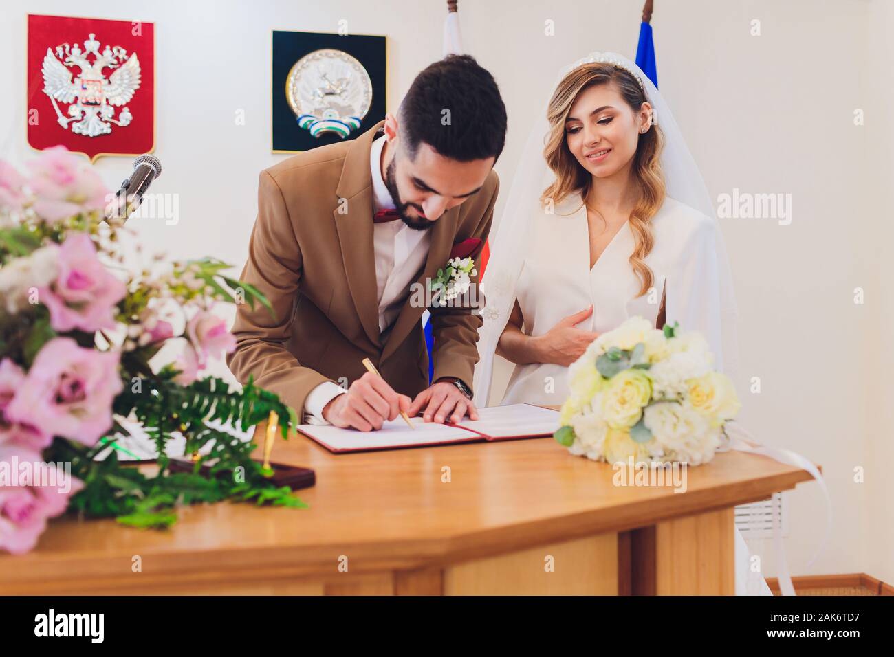 newlyweds append signatures in a registry office during wedding ...