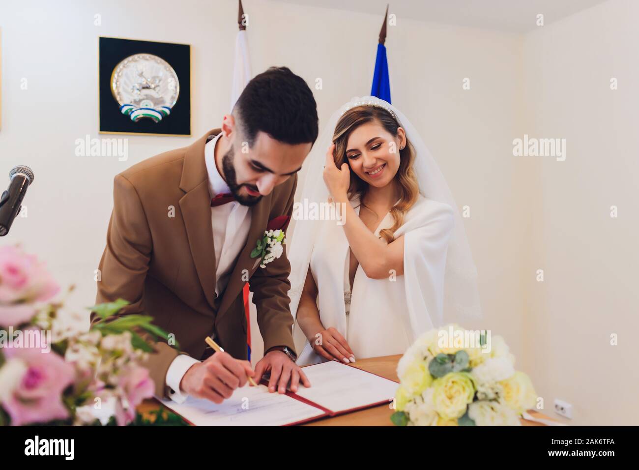newlyweds append signatures in a registry office during wedding ...