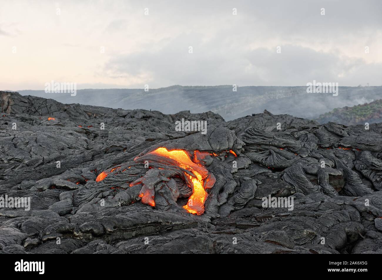 Hot magma of an active lava flow emerges from a fissure, the heat of ...