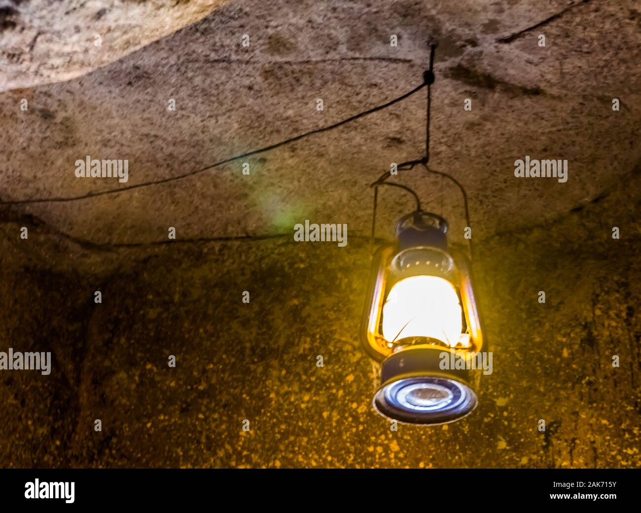 retro lantern hanging on the roof of a cave, Nostalgic mining equipment ...