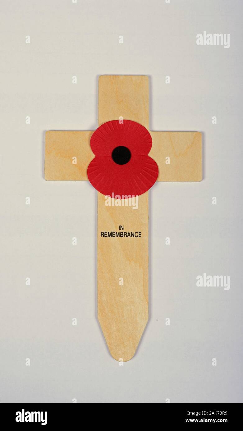 A single red poppy on a small wooden cross commemorating remembrance ...