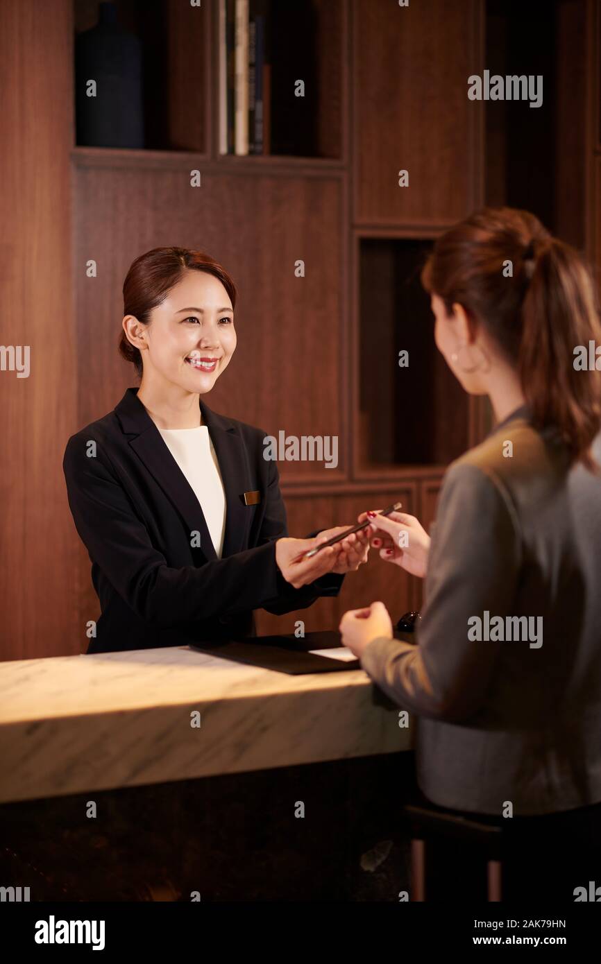 Young woman checking in at a hotel Stock Photo - Alamy