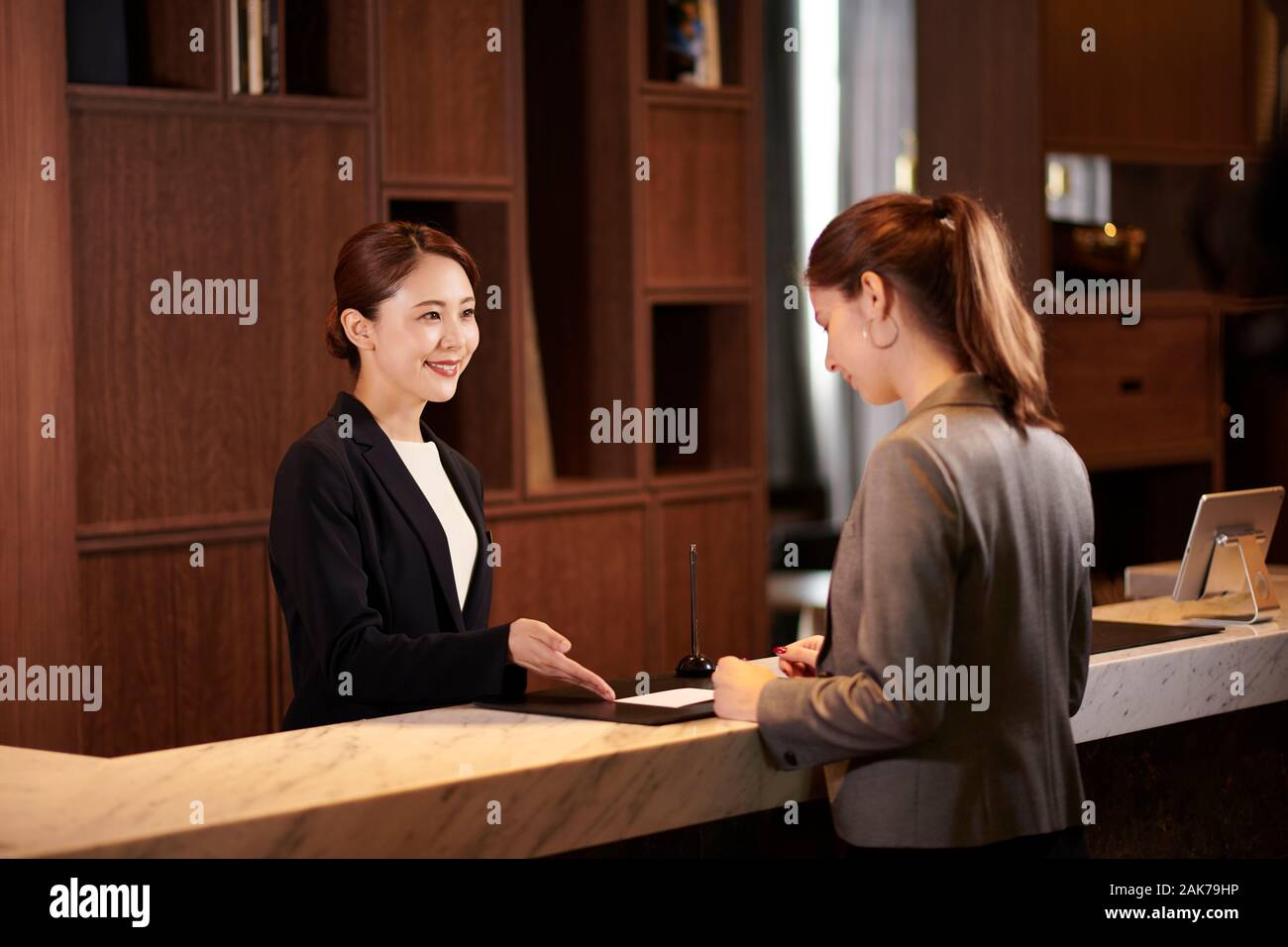 Young woman checking in at a hotel Stock Photo - Alamy
