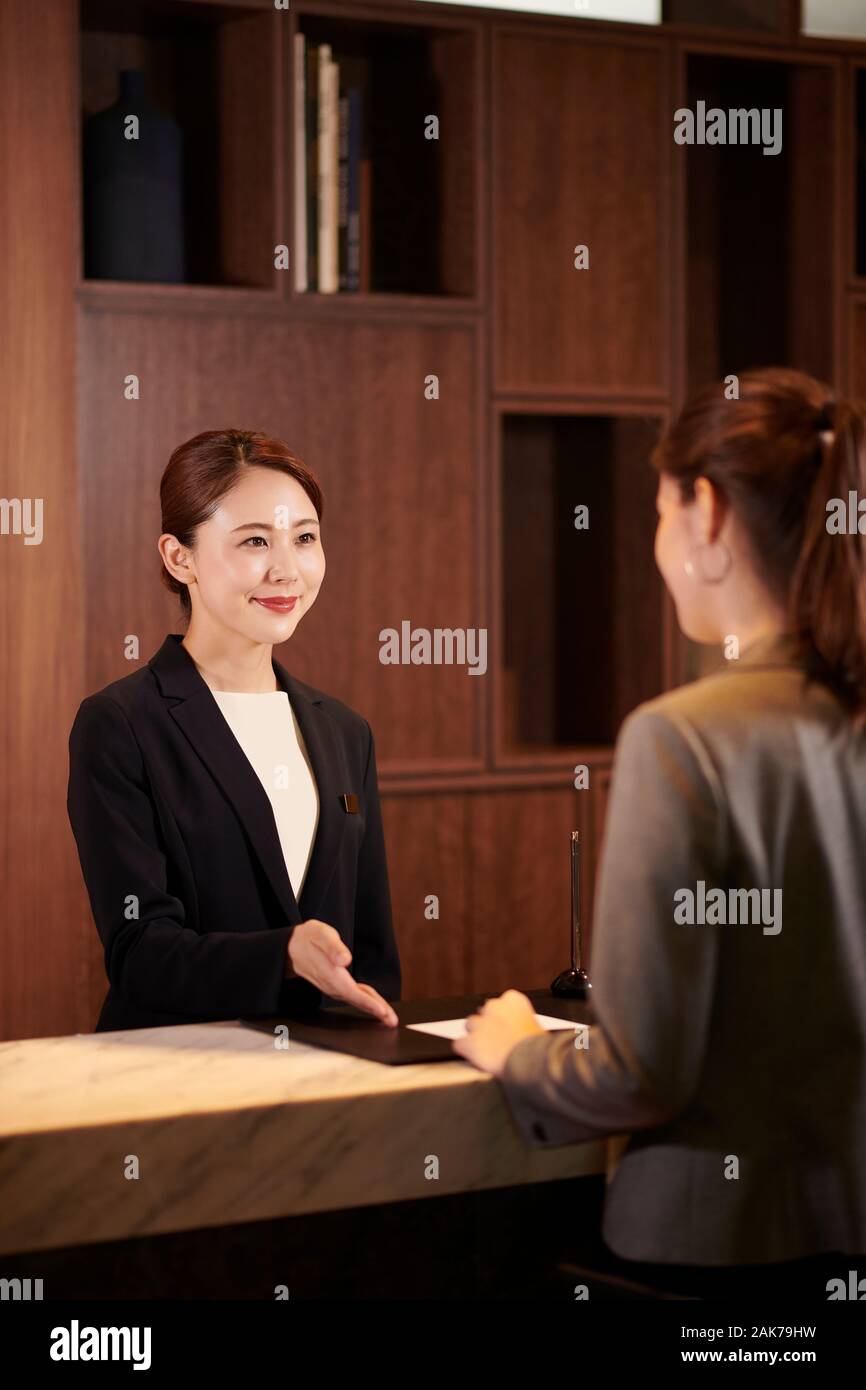 Young woman checking in at a hotel Stock Photo - Alamy