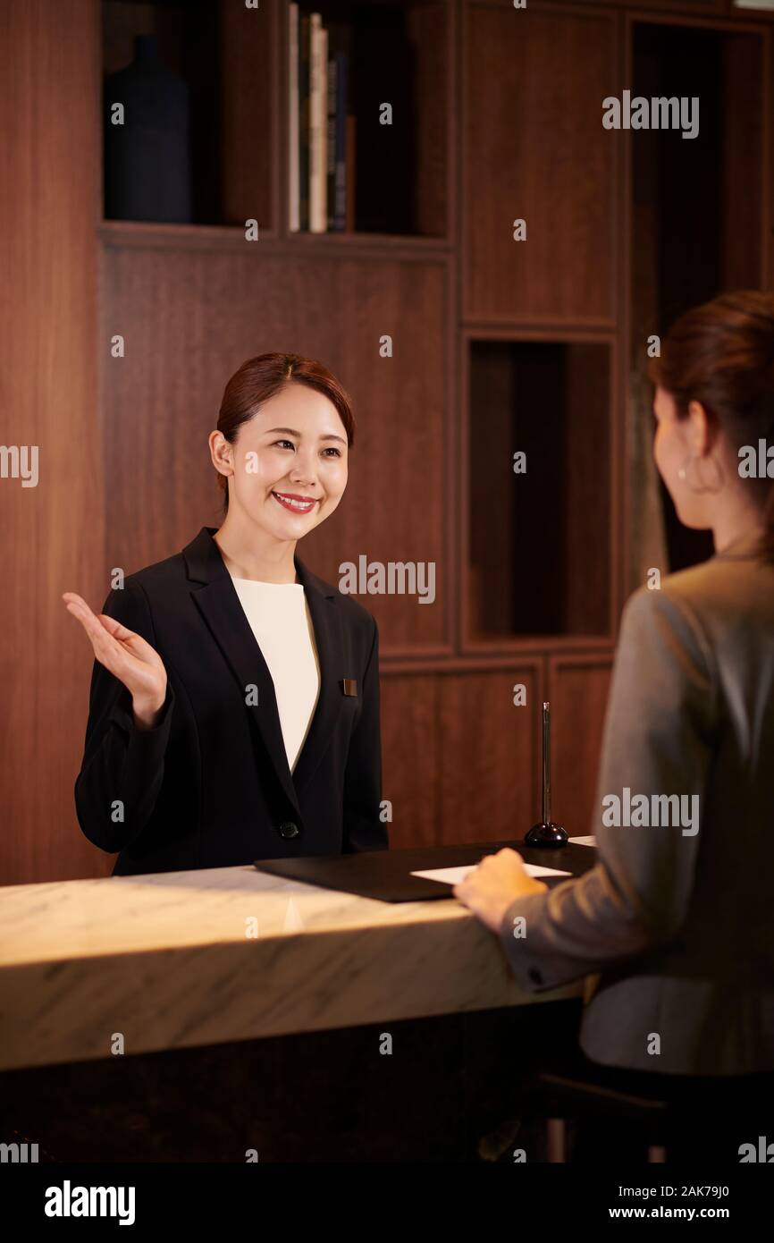 Young woman checking in at a hotel Stock Photo - Alamy