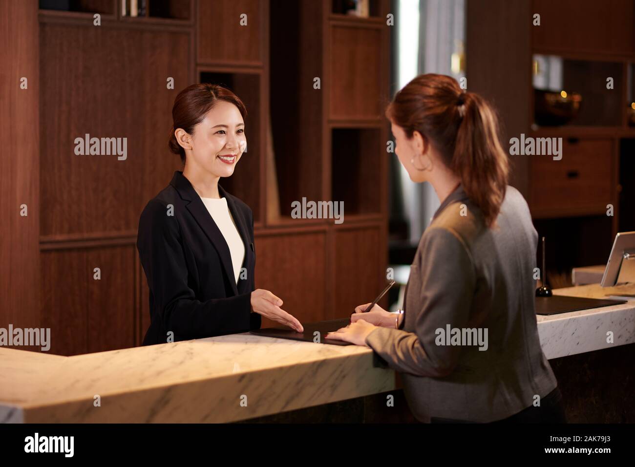 Young woman checking in at a hotel Stock Photo - Alamy