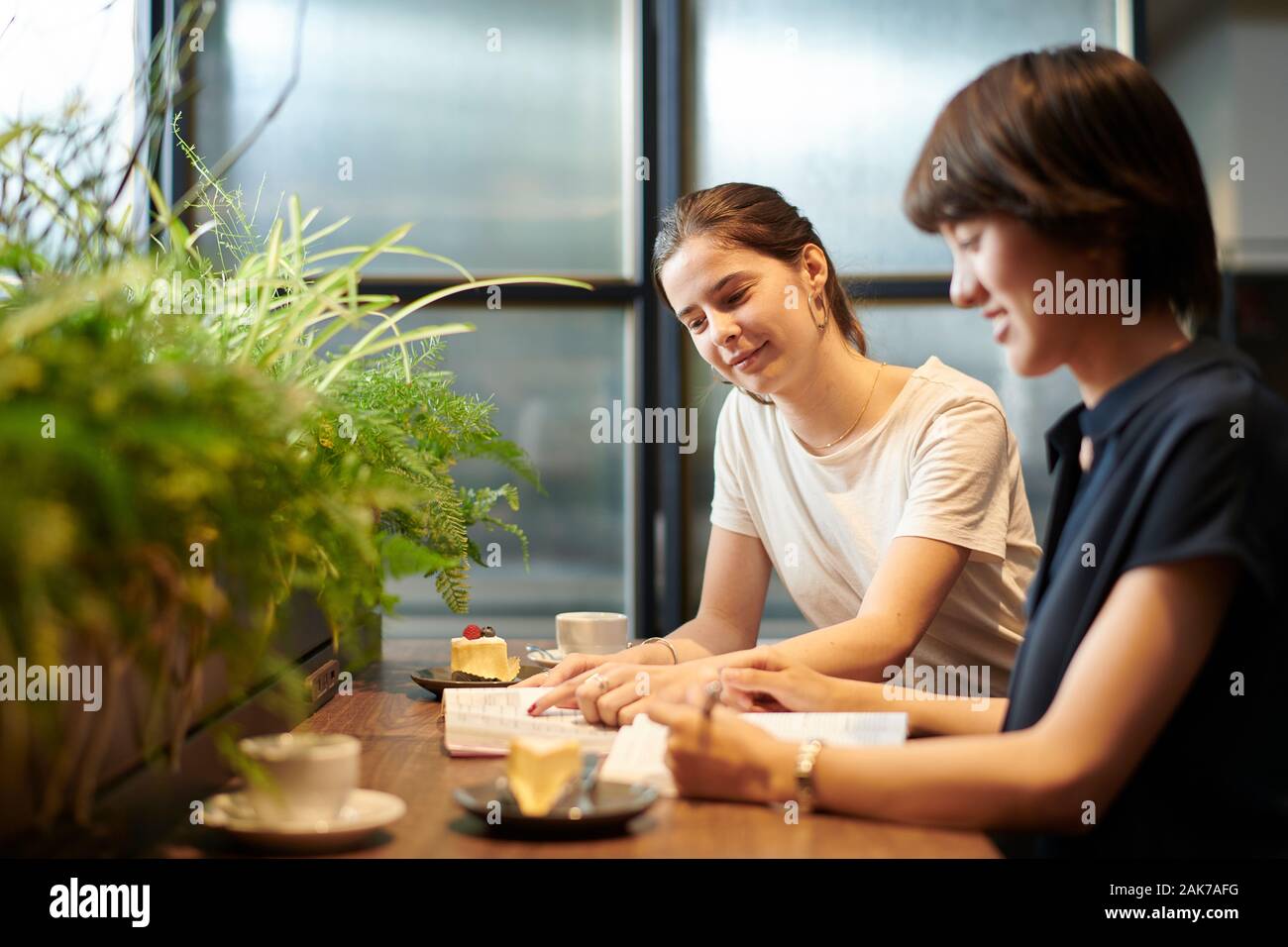 Young girlfriends at a cafe Stock Photo - Alamy