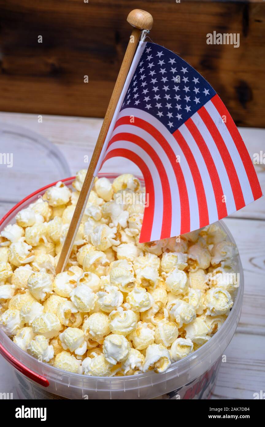 Plastic bucket with tasty sweet popcorn ready to eat and flag of USA ...