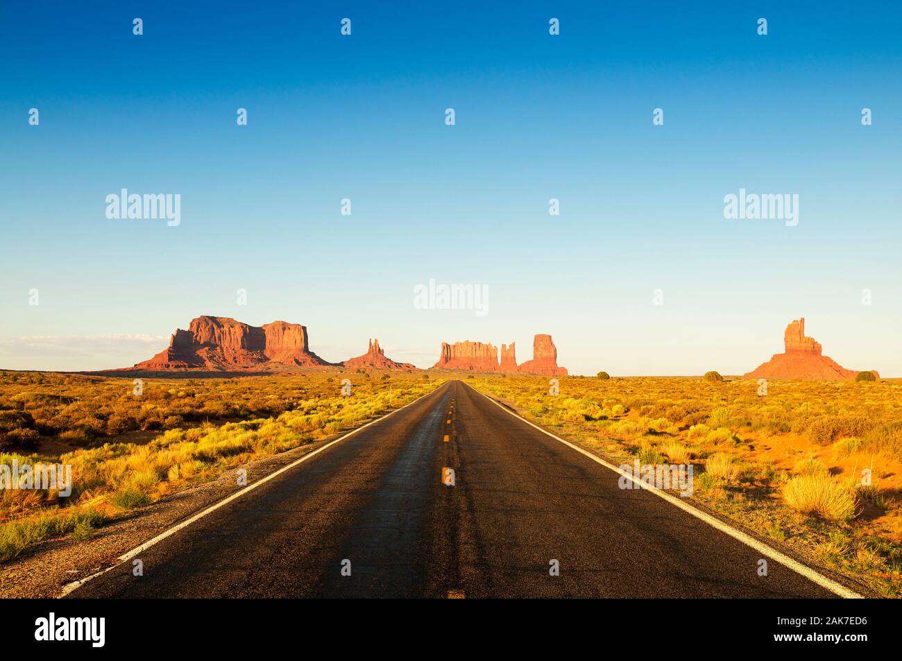 Empty straight road disappearing over the horizon dotted with iconic ...