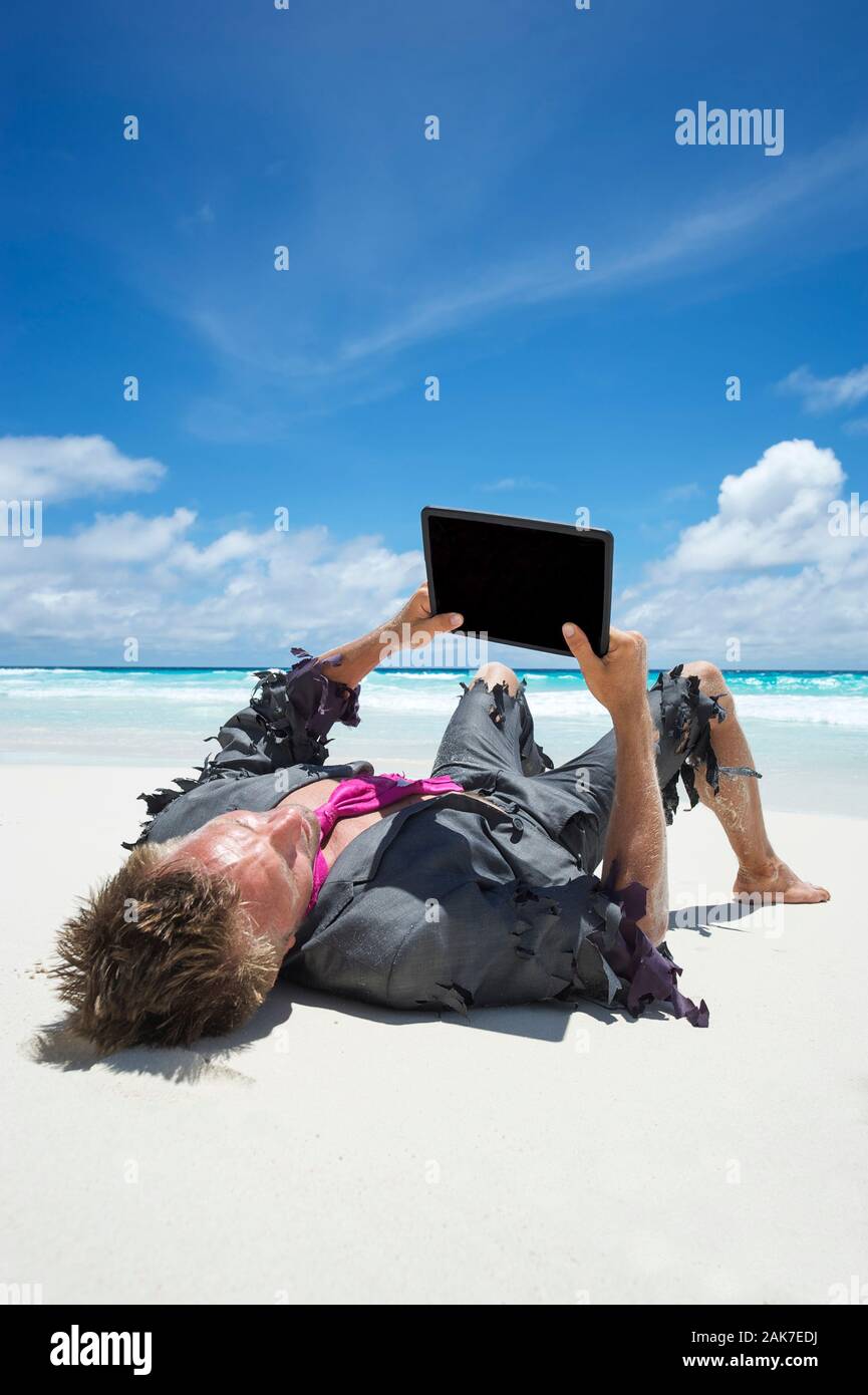 Castaway businessman relaxing with wifi on a tropical beach using his ...