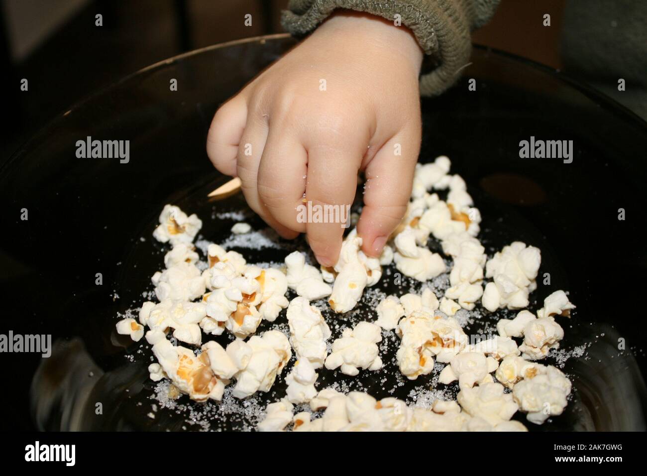 The child takes to eat popcorn from a plate hi-res stock photography ...