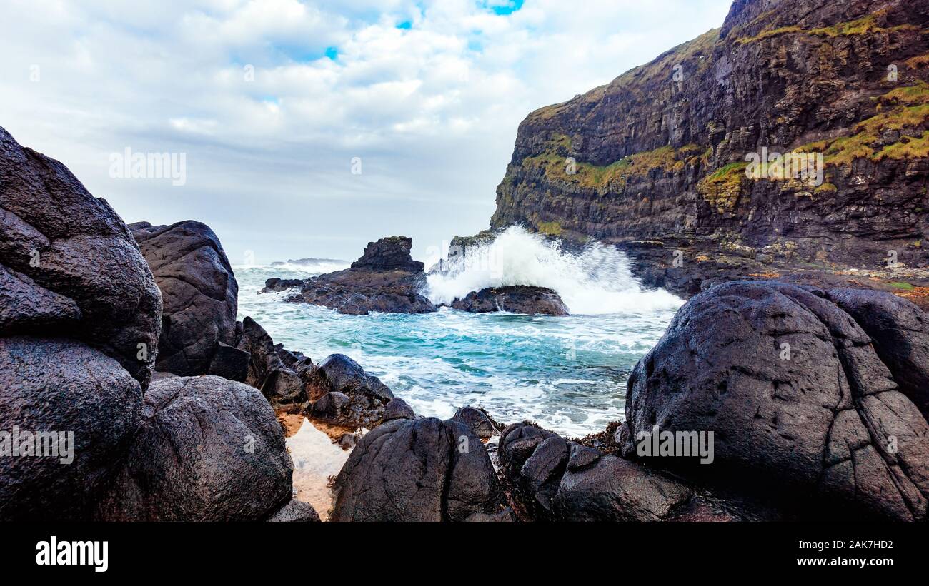 Waves crashing on cliff near Dunluce Castle where popular TV series ...