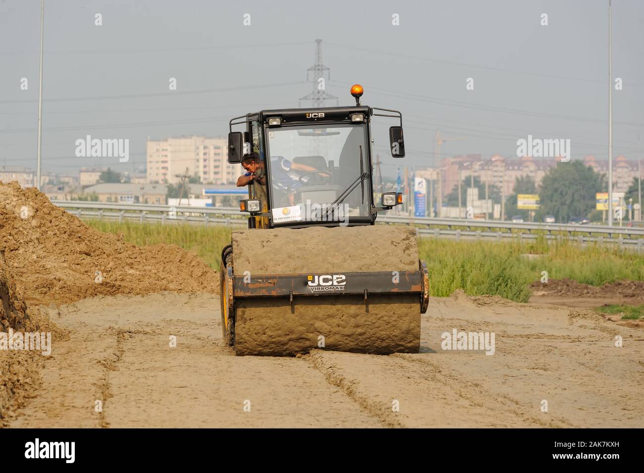 Road roller compressing sand to highway Stock Photo - Alamy