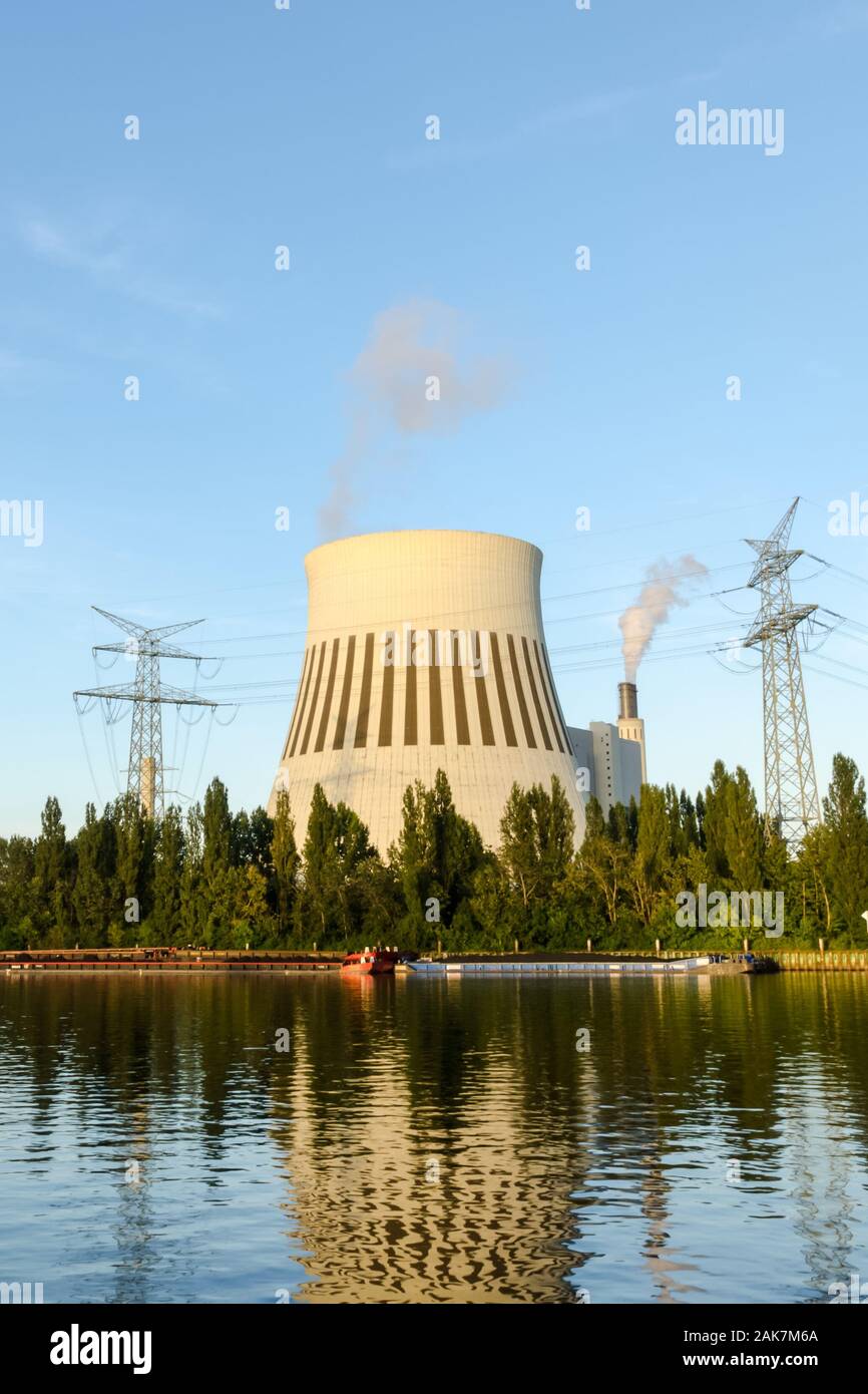 Cooling tower of a coal-fired power station with electricity pylons and ...