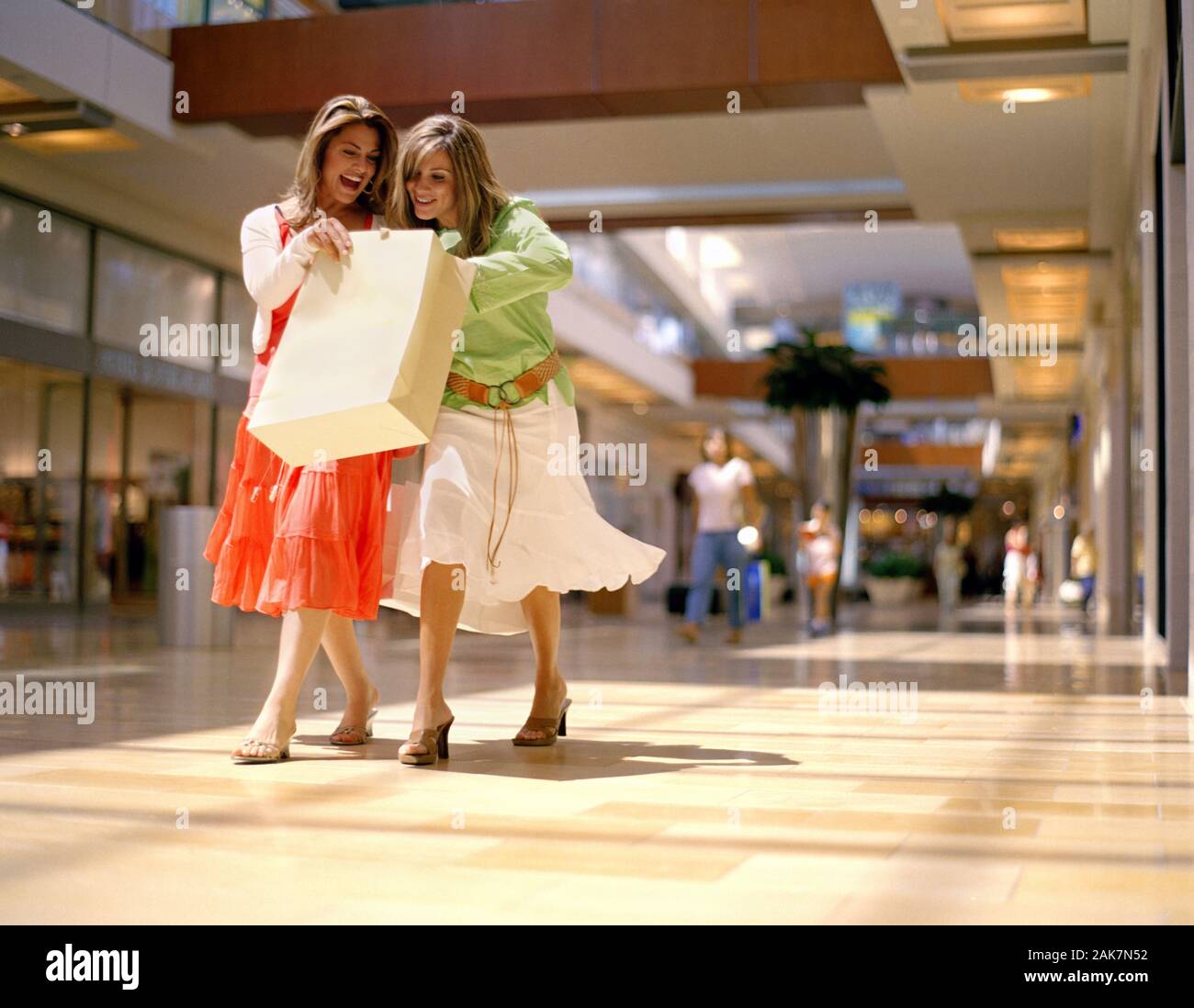 Two women walking through shopping area Stock Photo - Alamy