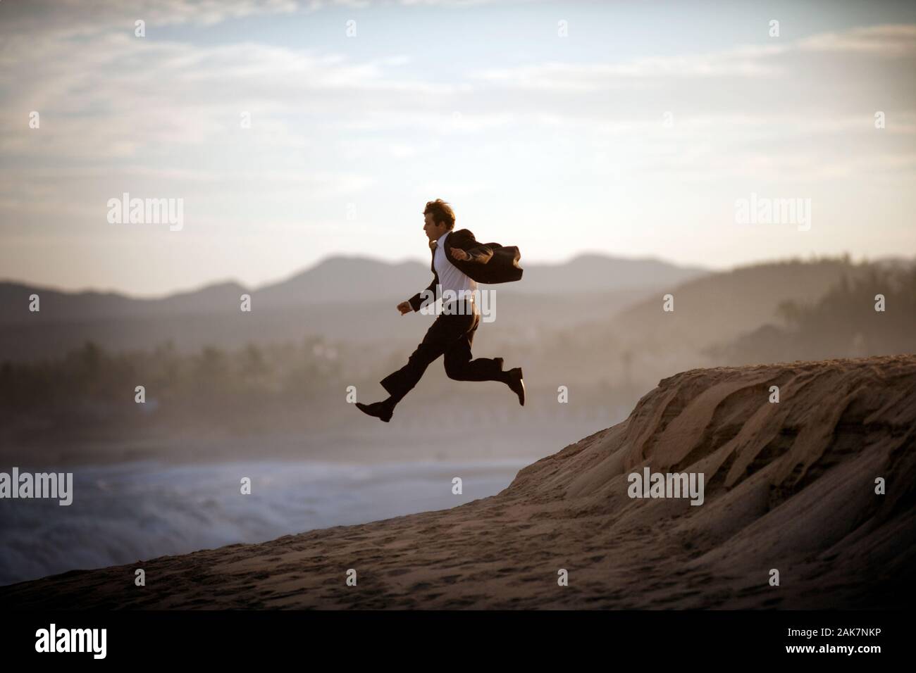 A man is seen in mid air as he jumps from the landform Stock Photo - Alamy
