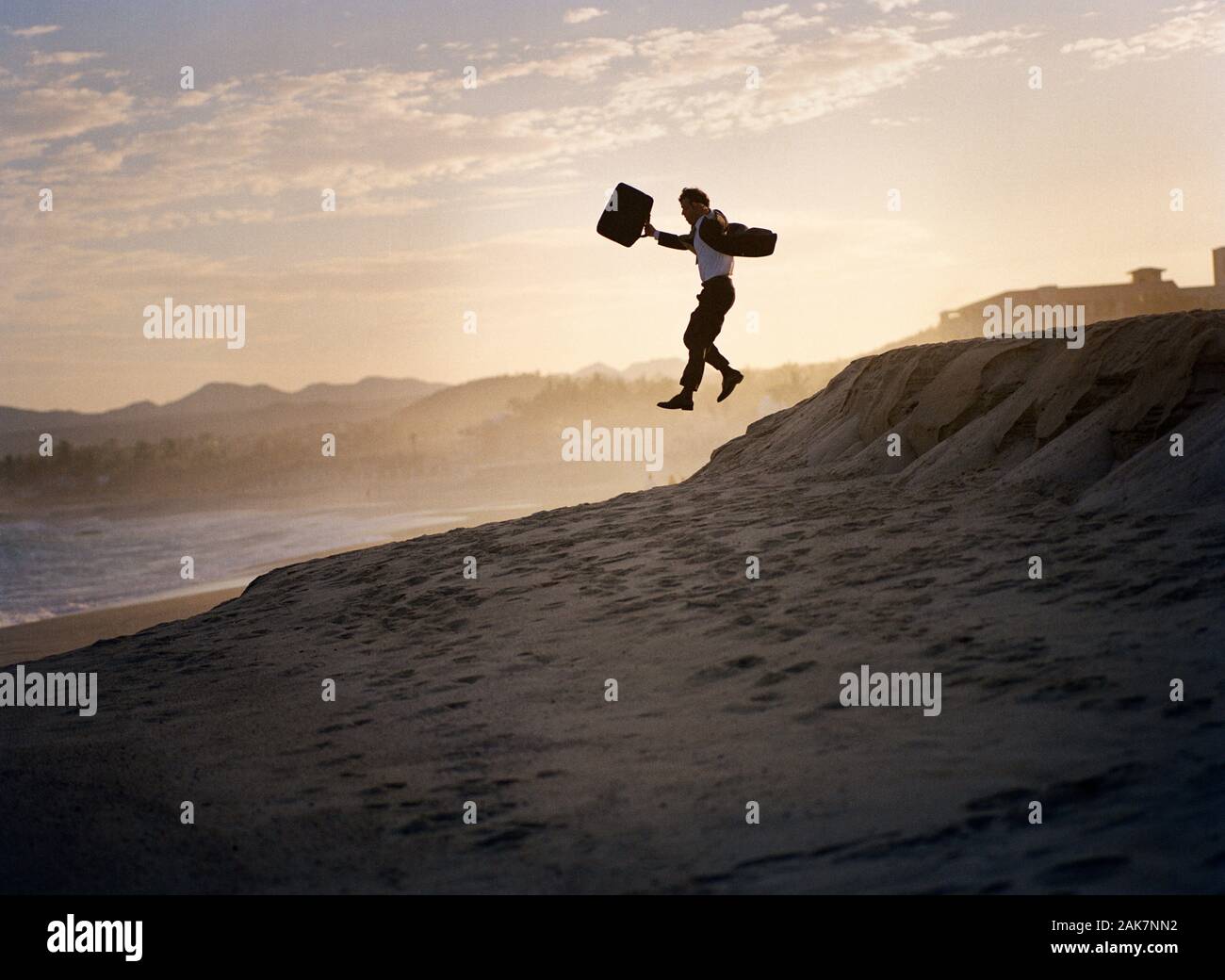 A man is seen in mid air as he jumps from the landform Stock Photo - Alamy