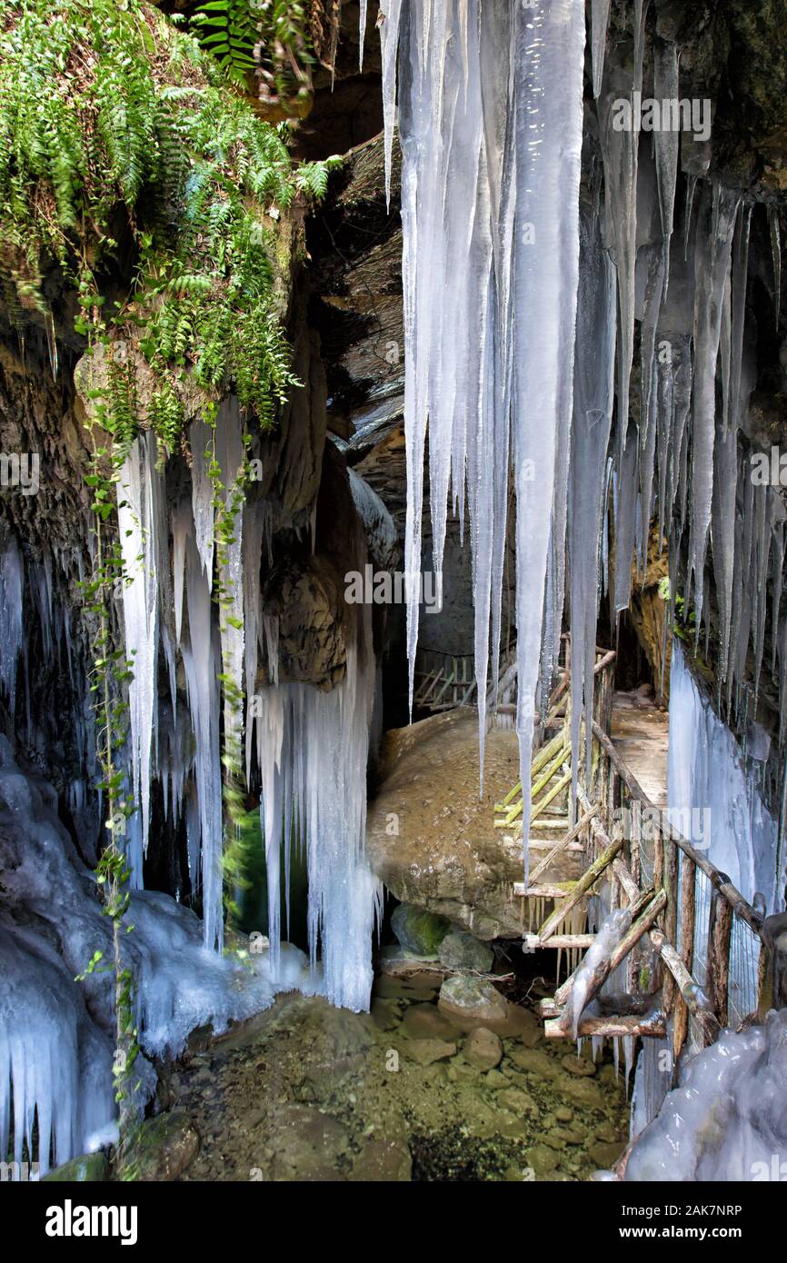 View of stalactites and stalagmites of ice at the entrance of a cave ...