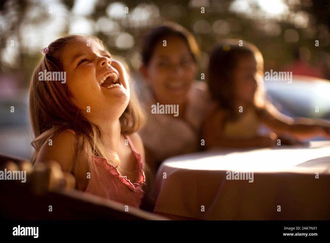 Side view of a little girl laughing while her mother looks on Stock ...