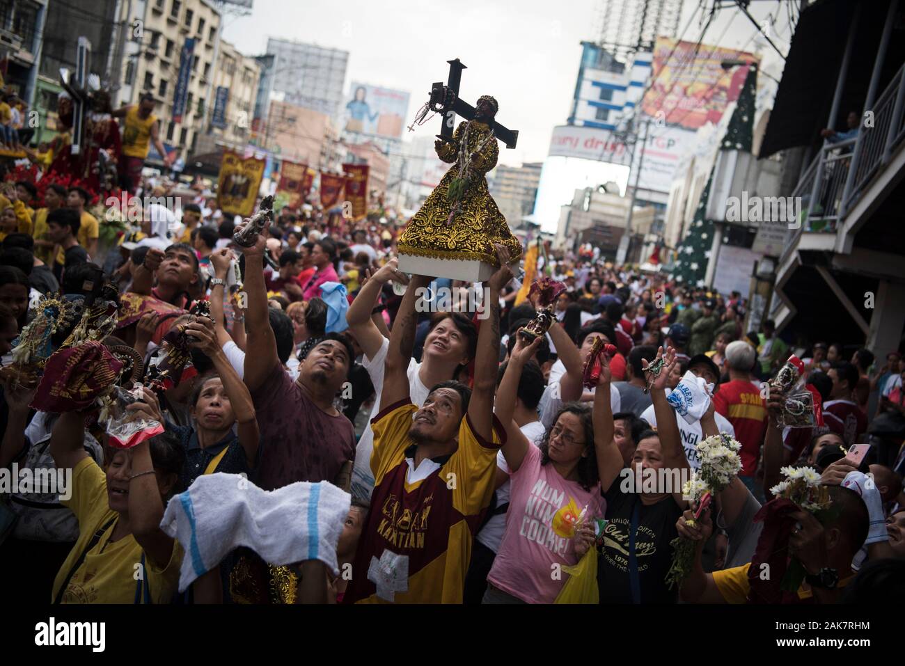 A man lifts a replica of the Black Nazarene sculpture during the parade ...