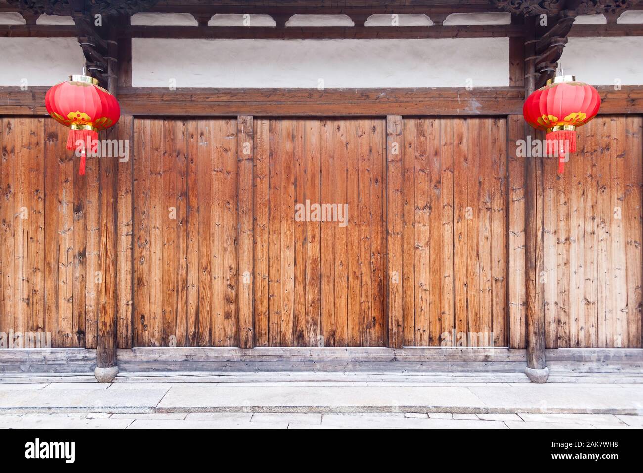 The traditional Chinese wooden gate with two red lanterns hanging at ...