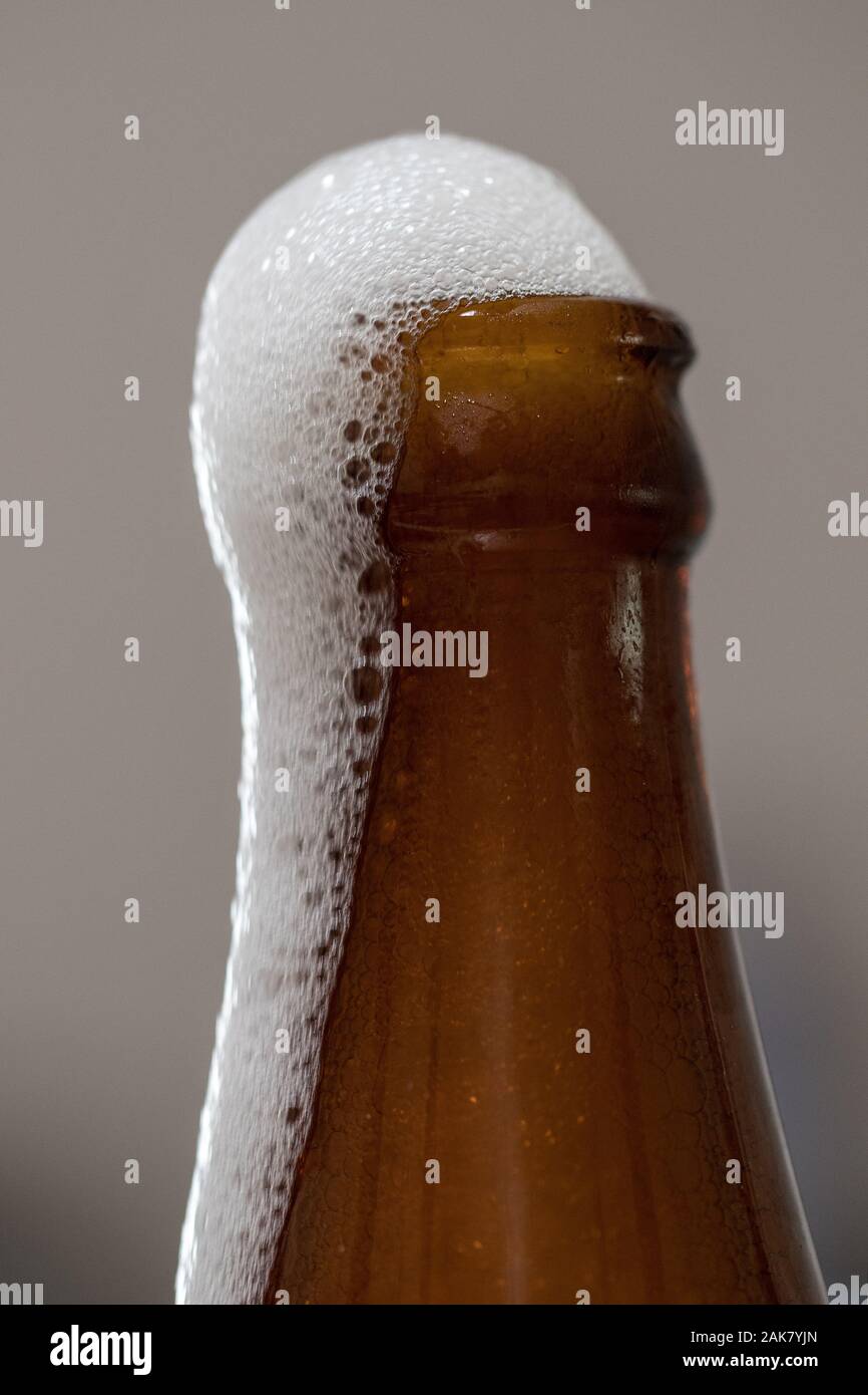 Beer flowing from just opened bottle Stock Photo - Alamy