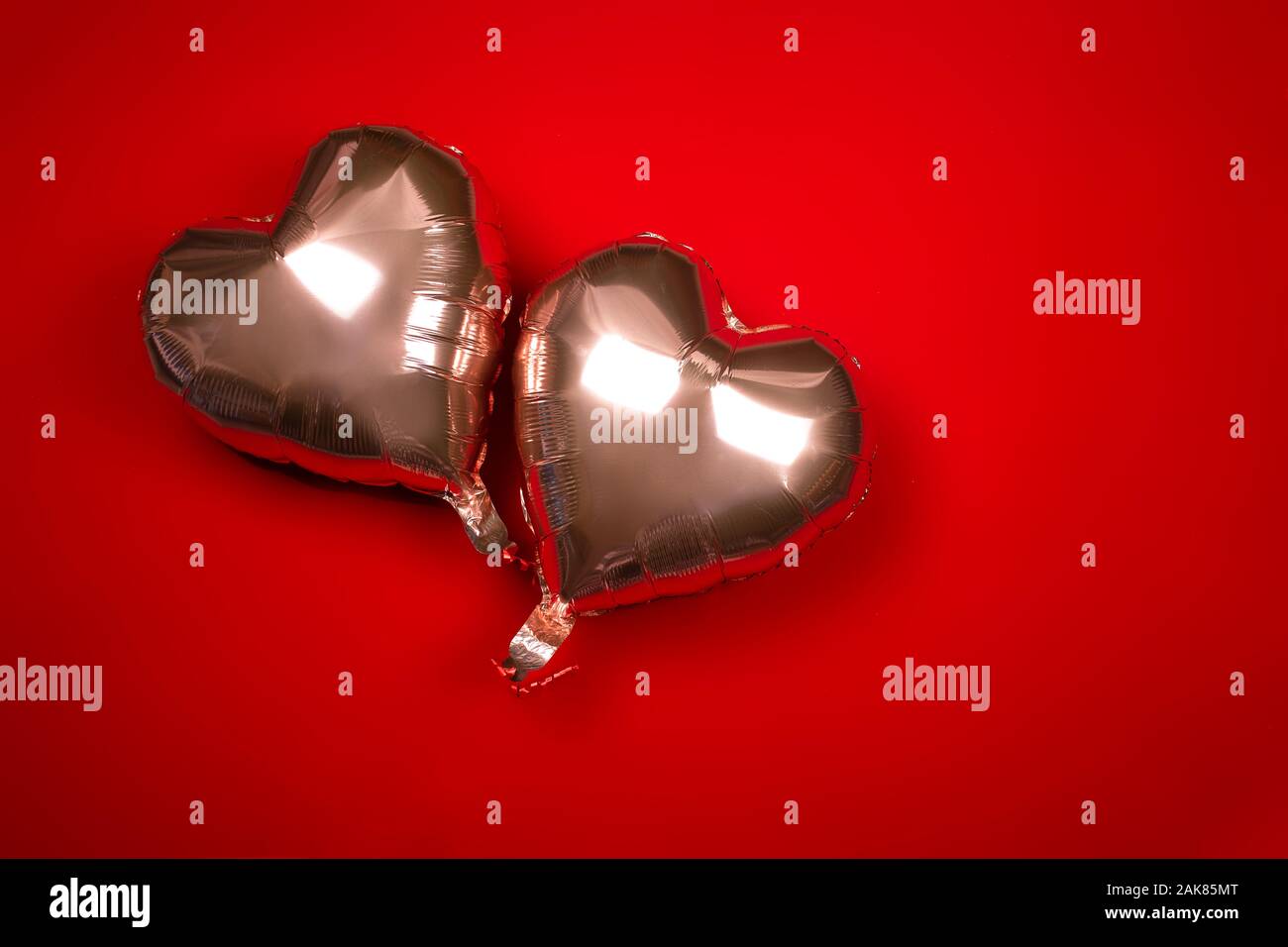 Two baloons heart shape on red background Stock Photo - Alamy