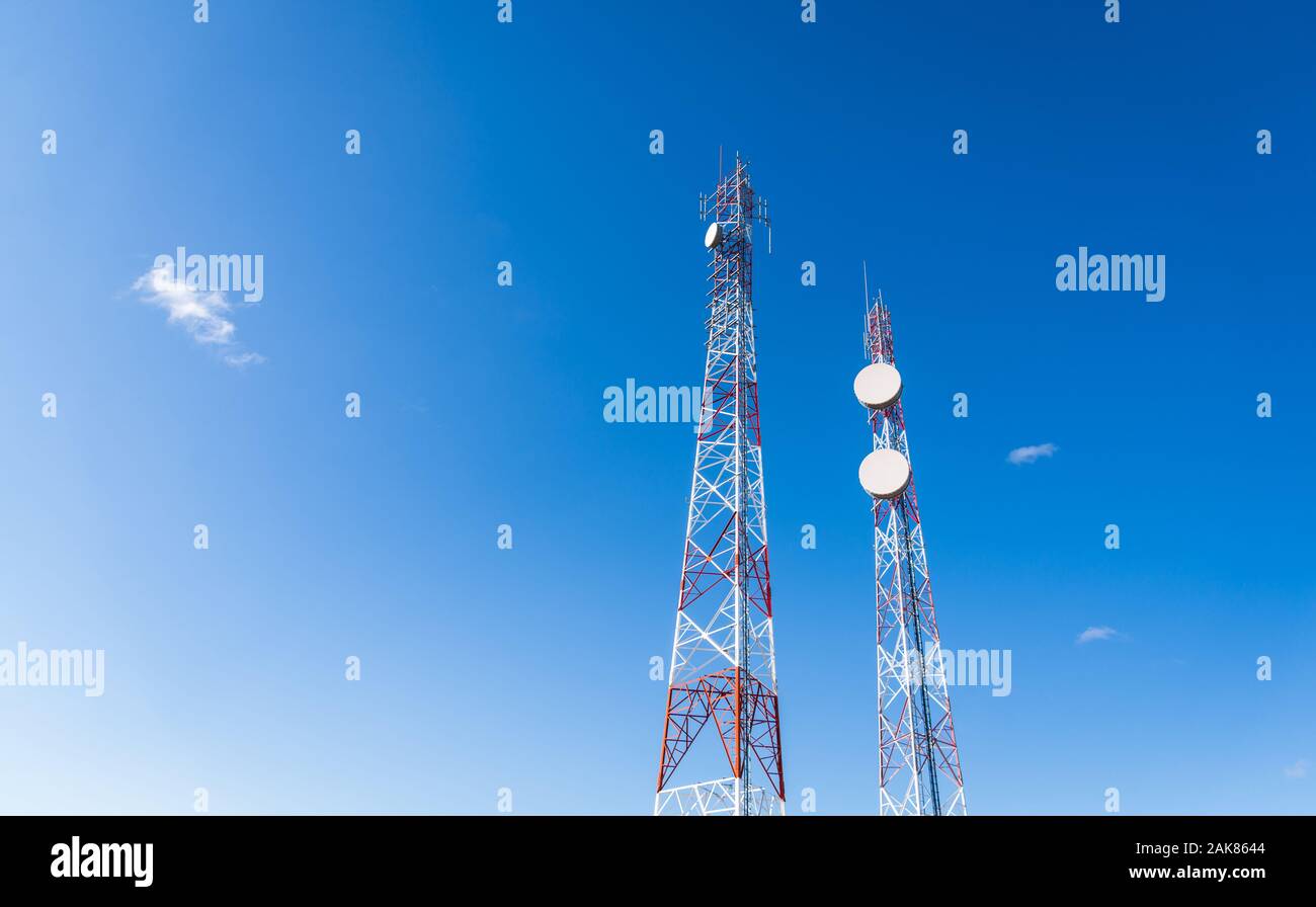 Colorful mobile phone network telecommunication tower against blue sky ...