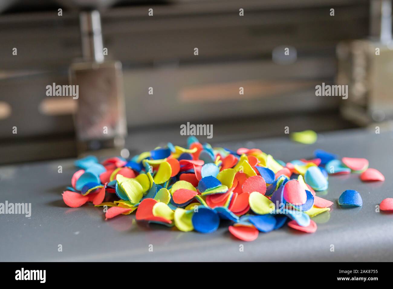 Paper Chads produced by punching holes in a sheets of colored paper ...