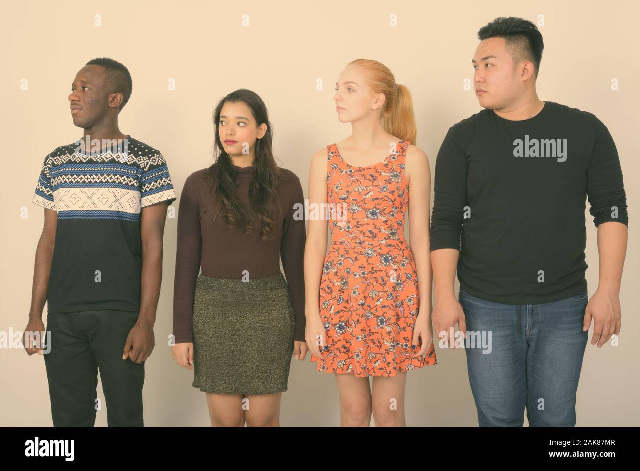 Studio shot of diverse group of multi ethnic friends looking at the ...