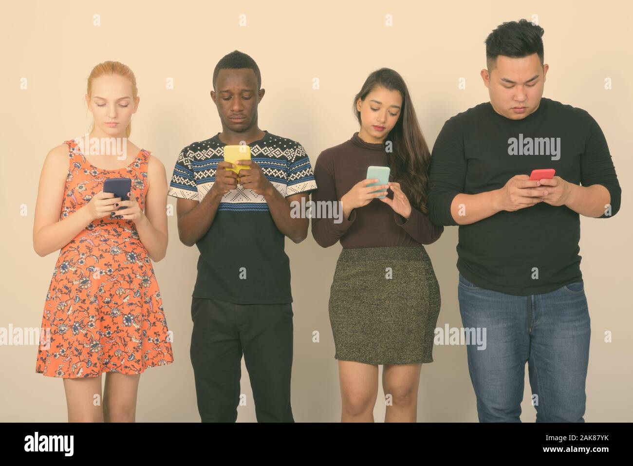 Studio shot of diverse group of multi ethnic friends using mobile ...