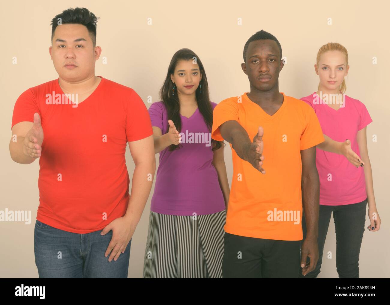 Studio shot of diverse group of multi ethnic friends giving handshake ...