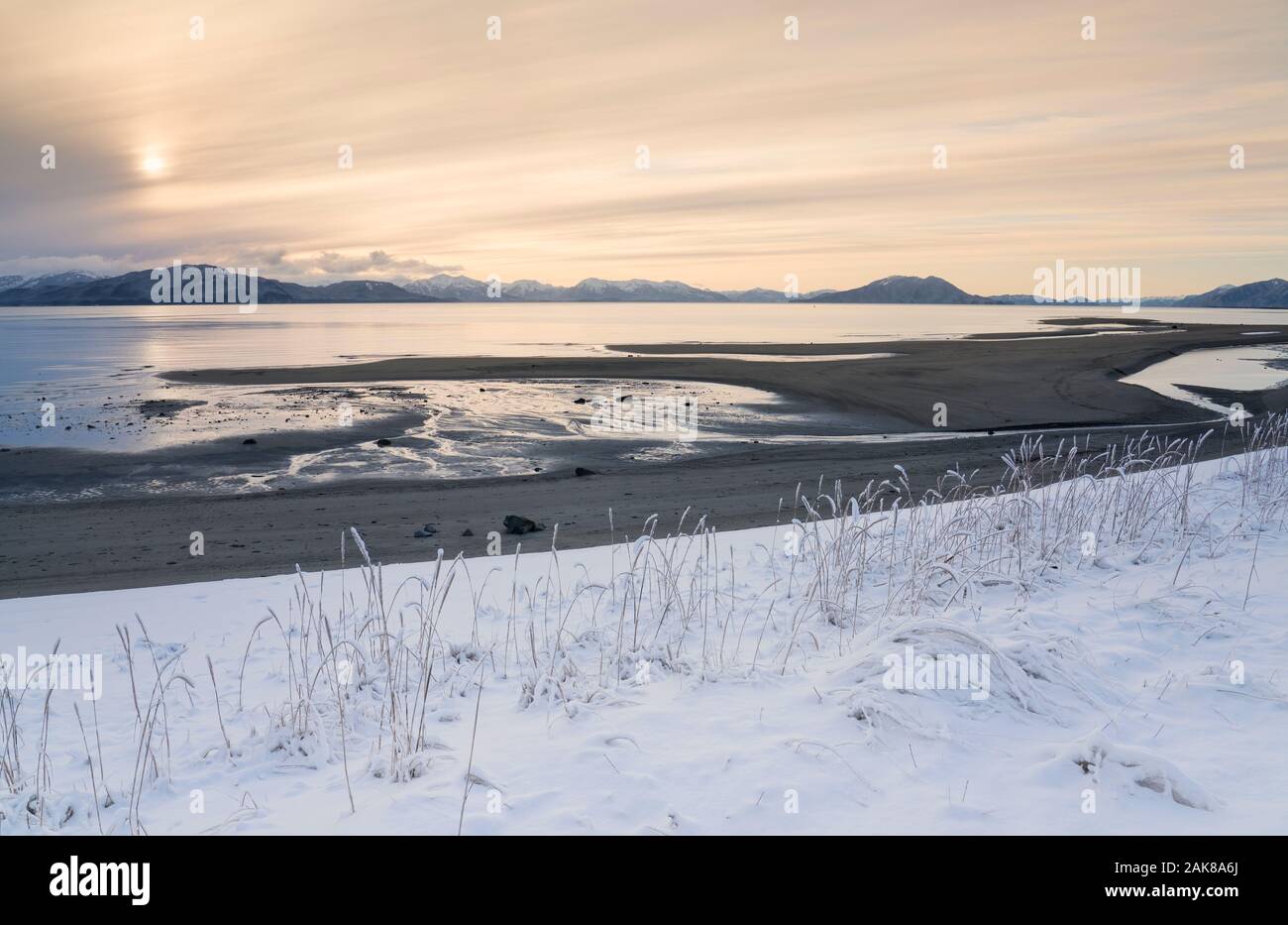 Snow on a beach in Southeast Alaska at low tide with a sunset sky Stock ...