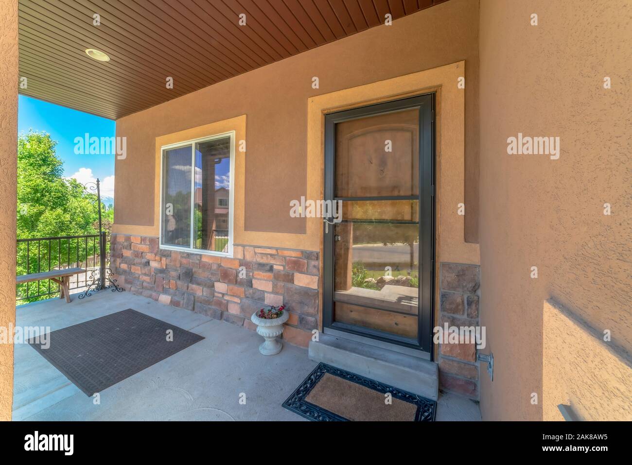 Home exterior view with porch and glass door in front of the brown ...