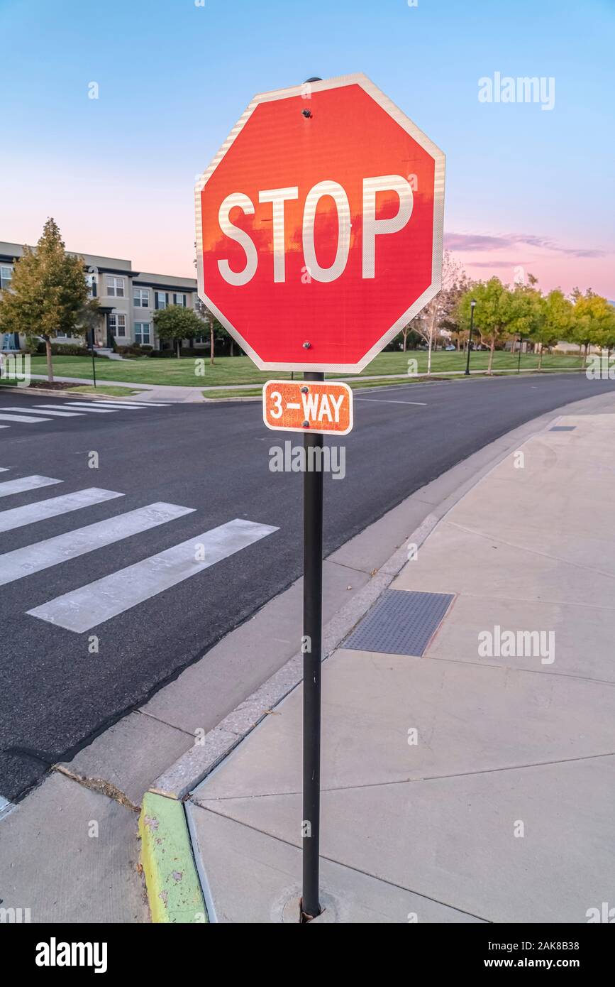 3-Way Stop at a street intersection at sunset Stock Photo - Alamy