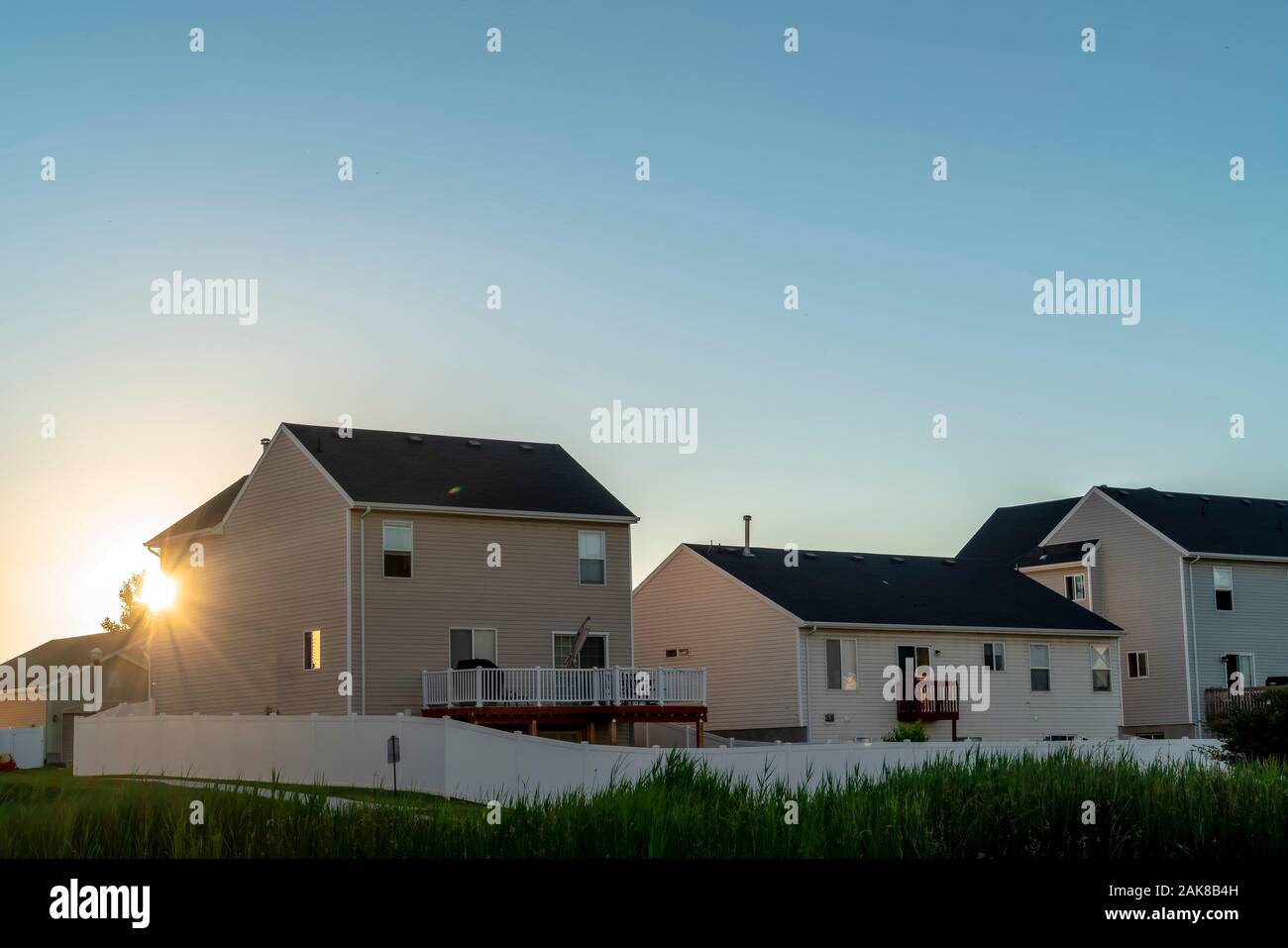 Exterior view of lovely homes with bright sun and blue sky background ...