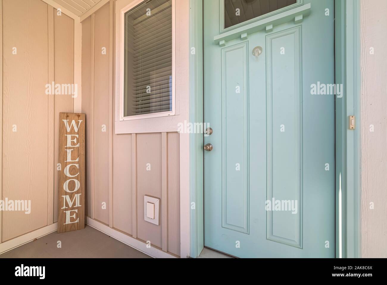 Green wooden front door with welcome sign Stock Photo - Alamy