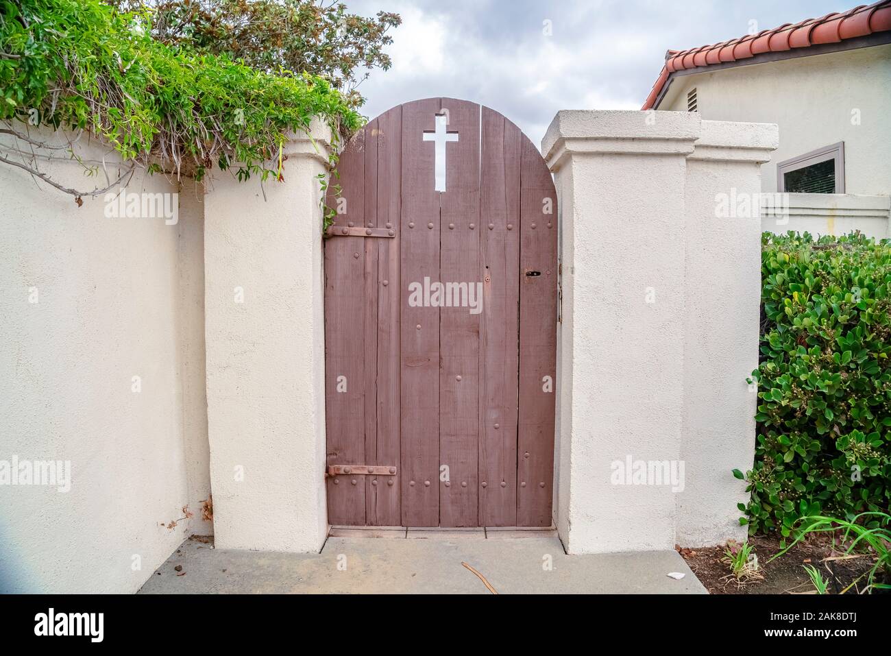 Entry gate to a church with a small white cross Stock Photo - Alamy