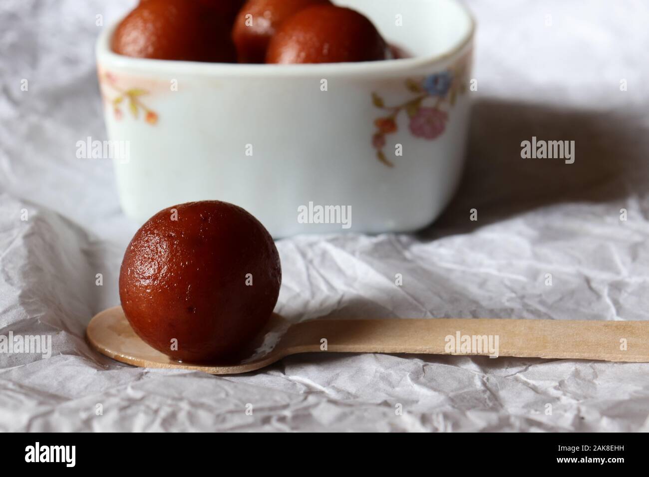 Close-up of a single gulab jamun in a bamboo spoon/Indian sweet Stock ...