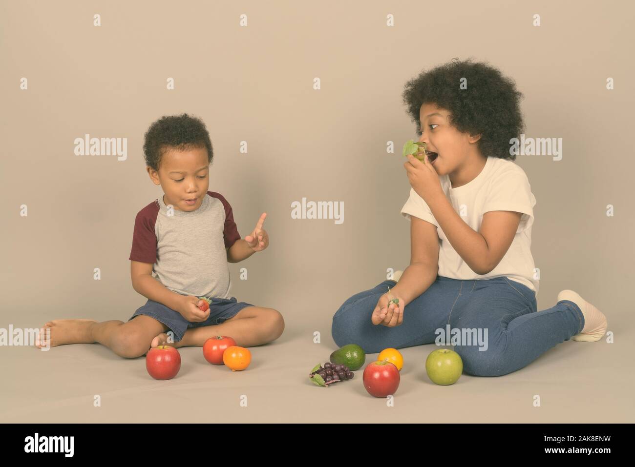 Young cute African siblings together against gray background Stock ...