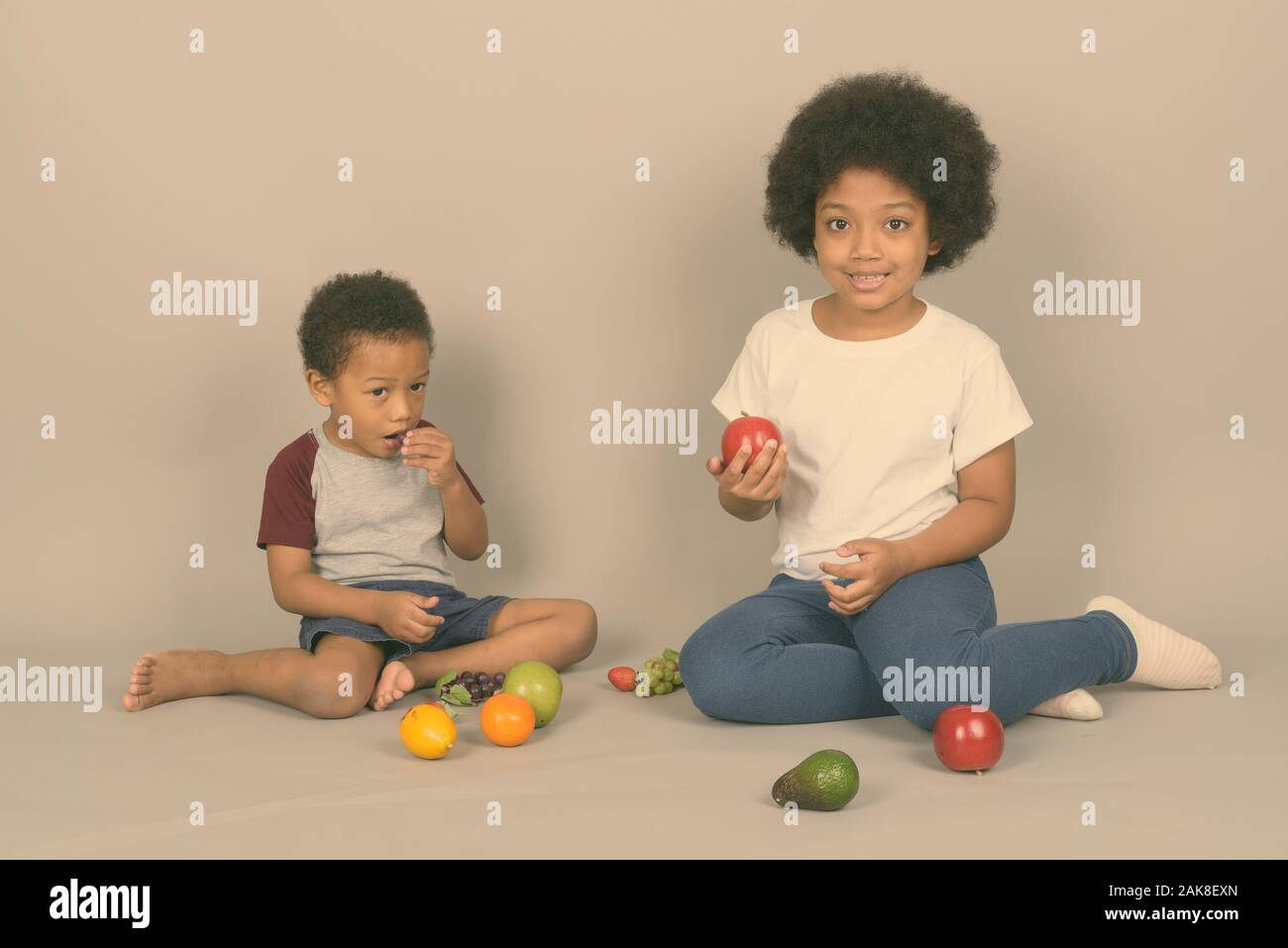 Young cute African siblings together against gray background Stock ...