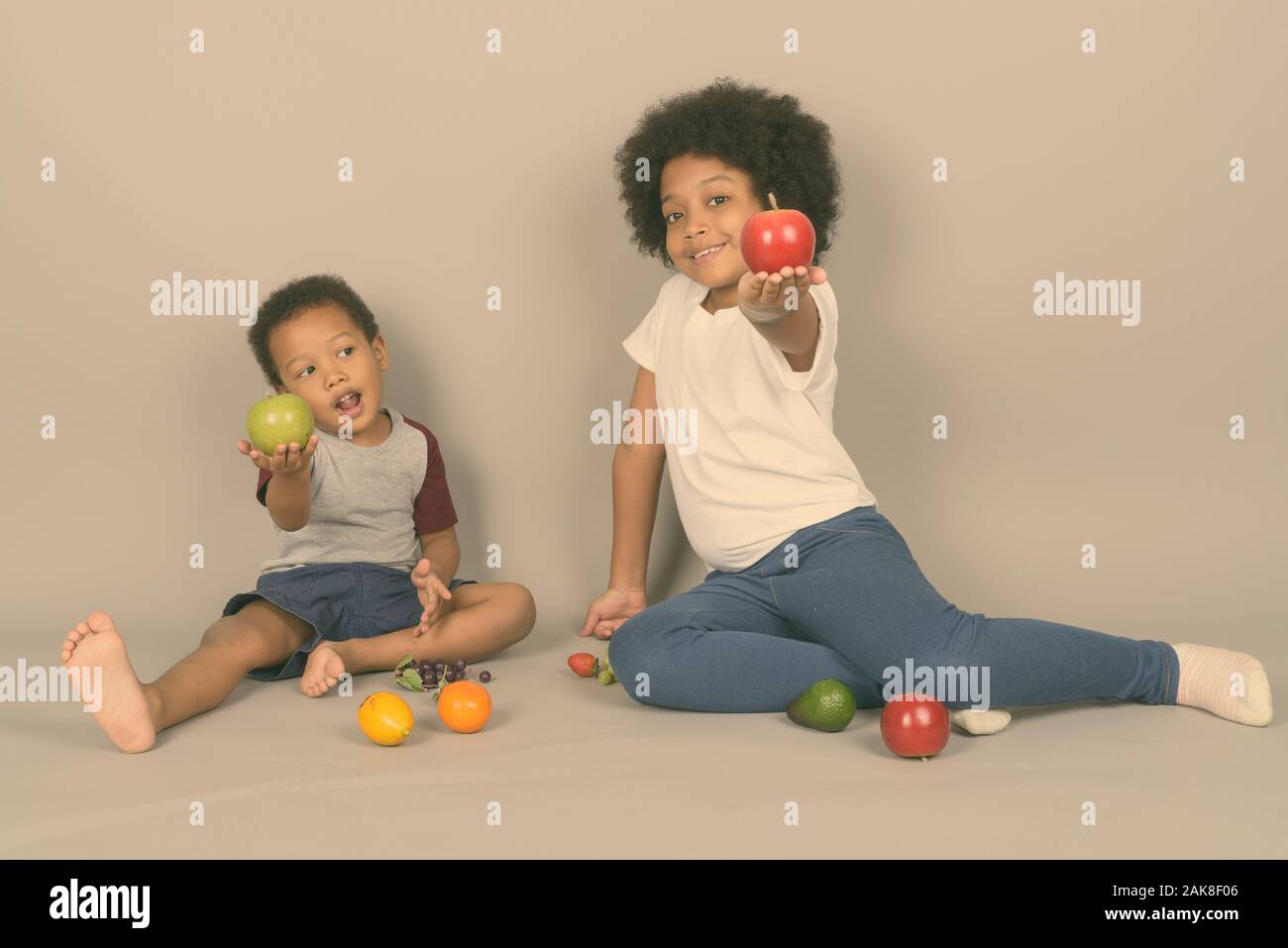 Young cute African siblings together against gray background Stock ...