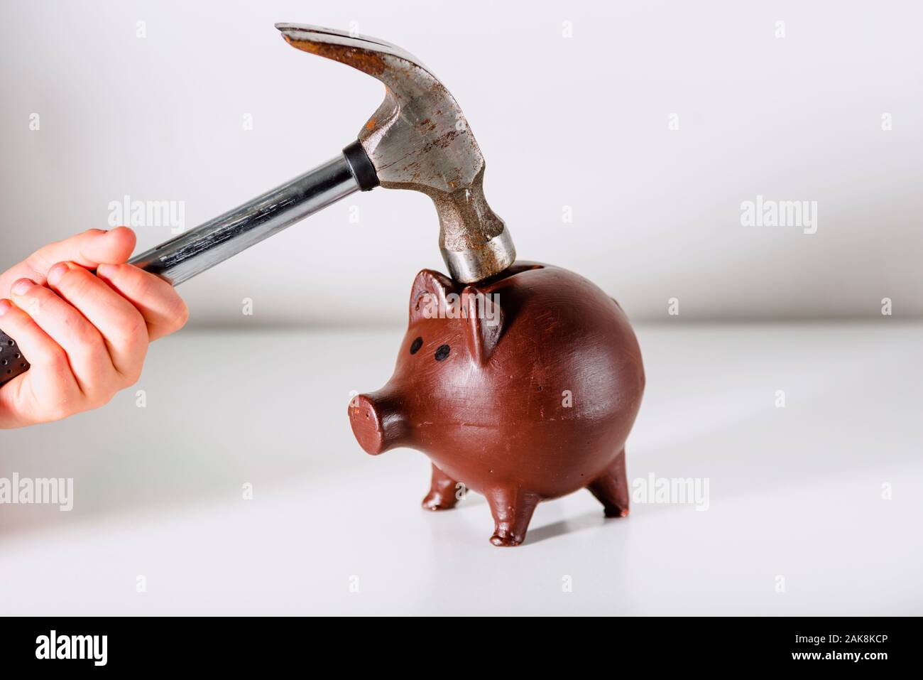 Hand hammers a piggy bank, isolated on white background Stock Photo - Alamy